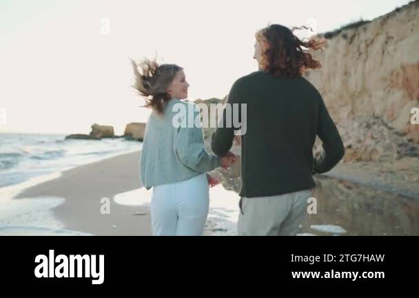 Back view of friendly couple running and hugging on the beach Stock ...