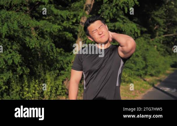 Asian Athlete running on the track feels sharp pain in the neck and ...