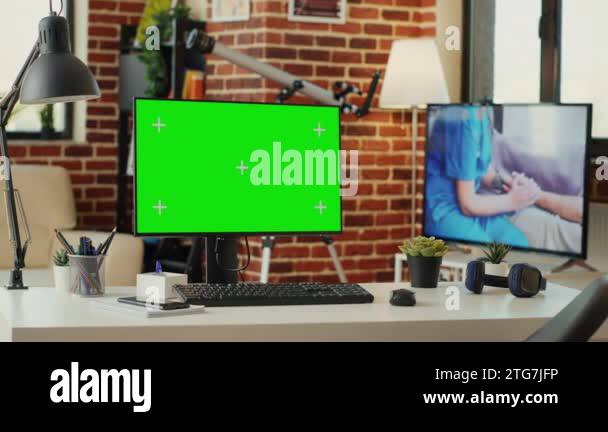 Empty office desk with greenscreen template on monitor, isolated mockup background running on ...