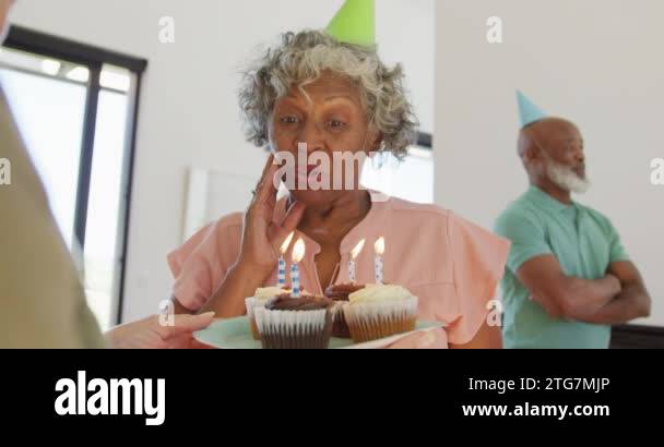 Happy senior diverse people at birthday party with cake at retirement ...