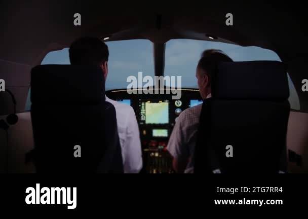 Two airplane pilots preparing for takeoff. Training in flight simulator ...