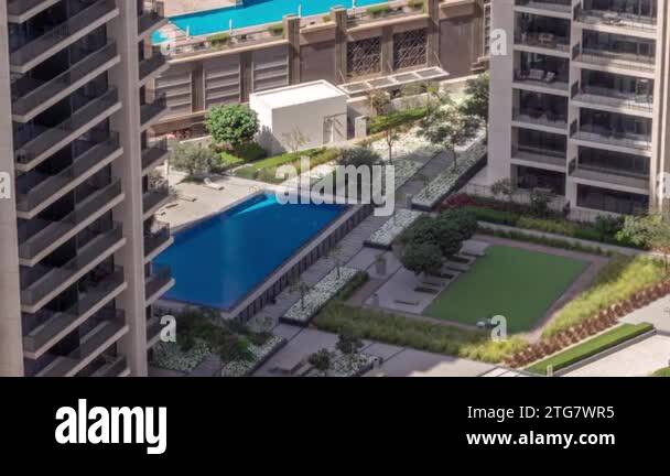 Relaxing area among skyscrapers with swimming pools and sunbed in Dubai ...