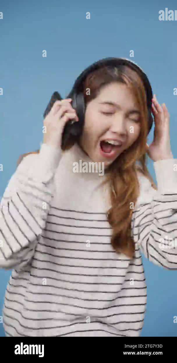 Youth Asia lady wear sweater hold telephone enjoy listen new popular songs on earphone in ...