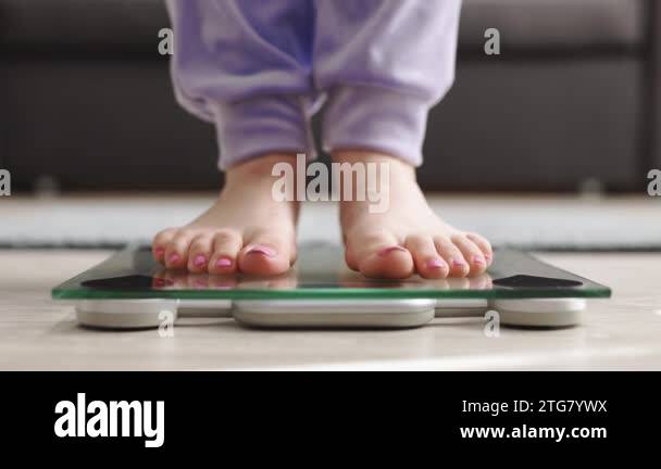 Woman on scales measure weight. Barefoot measuring body fat overweight ...