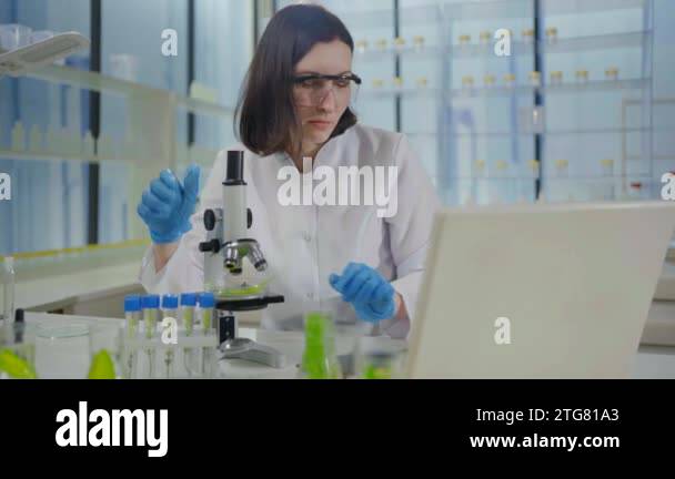 a Dissatisfied and puzzled, a female scientist looks through a ...