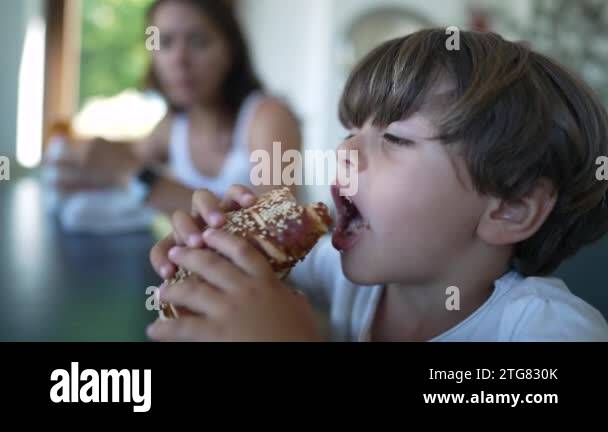 Little boy eating sandwich. Child taking a bite of bread. Kid eats ...