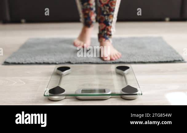 Legs of a girl standing on scale to measure weight. Caucasian female ...