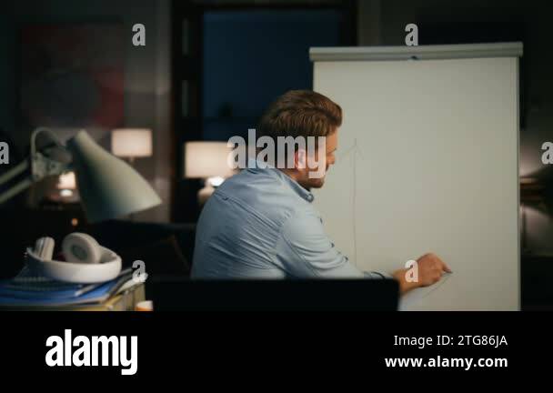 Confident man presenting project online at dark room. Young business ...