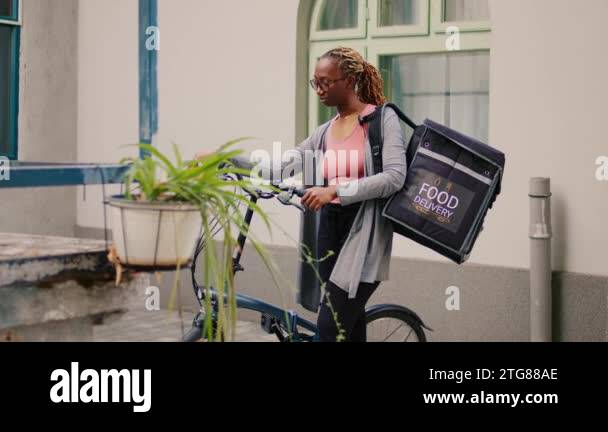 African american female carrier waiting to customer outdoors, standing ...