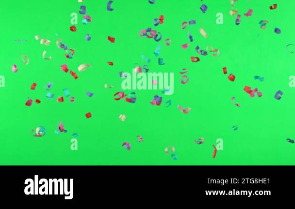Super slow motion of flying colored confetti isolated on green ...