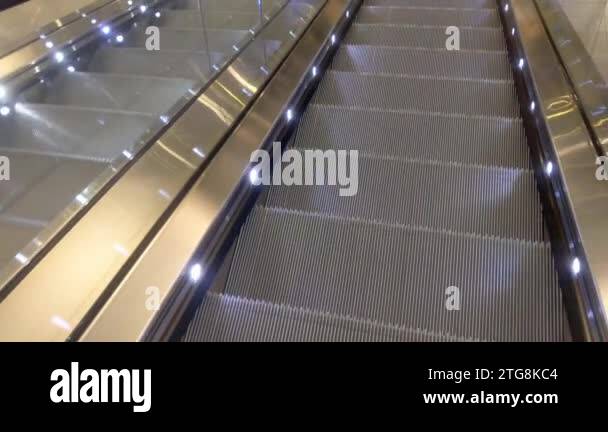 Downward movement on the elevator. Modern escalator stairs. Futuristic empty staircase ...