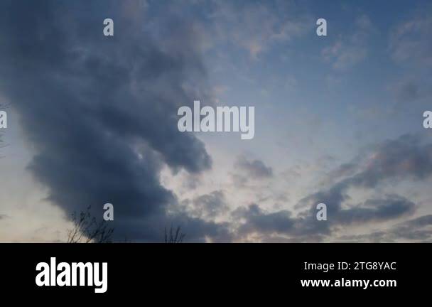 Beautiful clouds in the blue sky. Spring storm clouds with sun rays ...