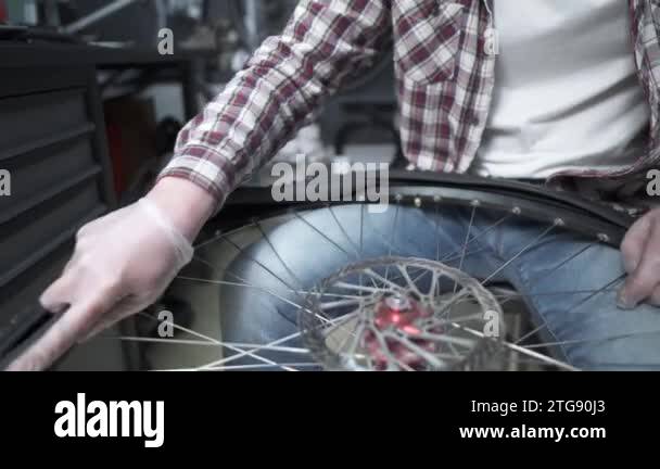 A bicycle mechanic changes a bike tube and tire and fixes a cycle wheel ...