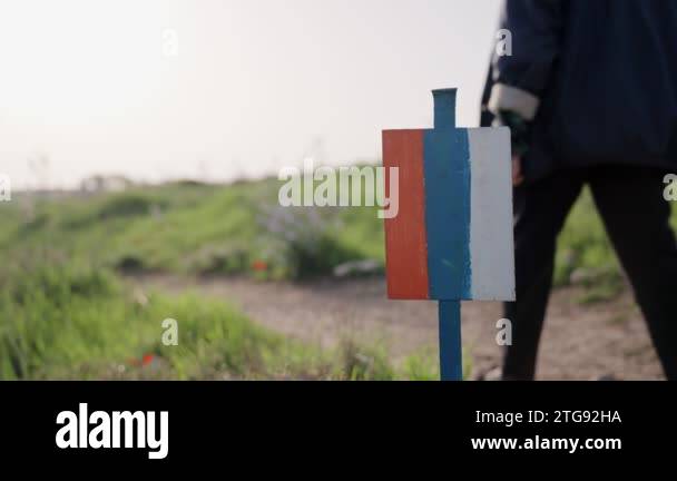 Close up on trail or path marking sign as woman hiker walks in ...