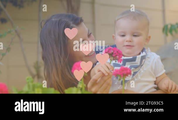 Animation of hearts over happy caucasian mother holding baby. family ...