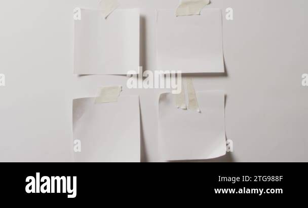 Video of close up of four white memo notes with copy space taped to ...