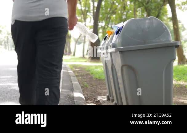 Asian elderly woman Take plastic bottles and throw them in the trash ...