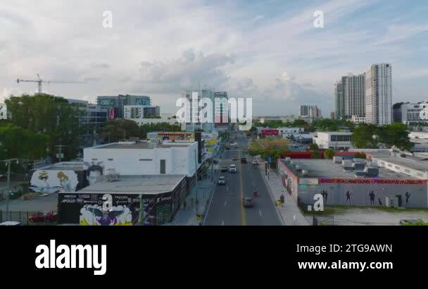Backwards fly above busy multilane street in urban neighbourhood in ...