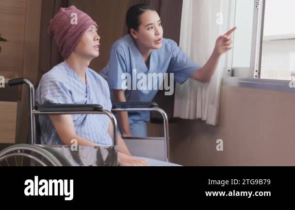 Uniformed young Asian female therapy doctor encouraging wheelchair male ...