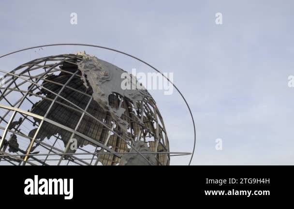 Plane appearing behind Unisphere Globe. Flying airplane and massive ...