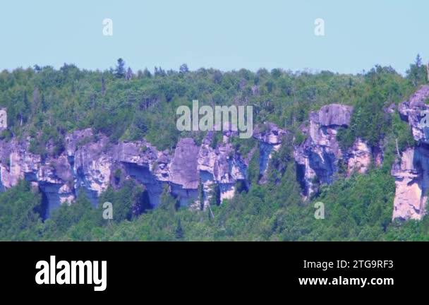 Limestone rocky cliff with green forest by Lake Huron Lion's Head Beach ...