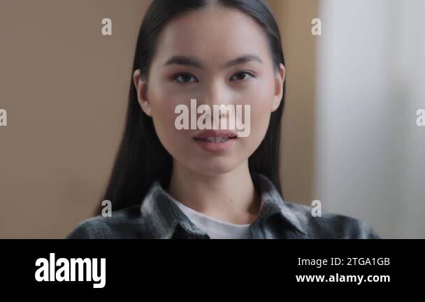 Confident 20s girl 30s asian ethnic woman perfect skin face looking at camera posing alone at ...