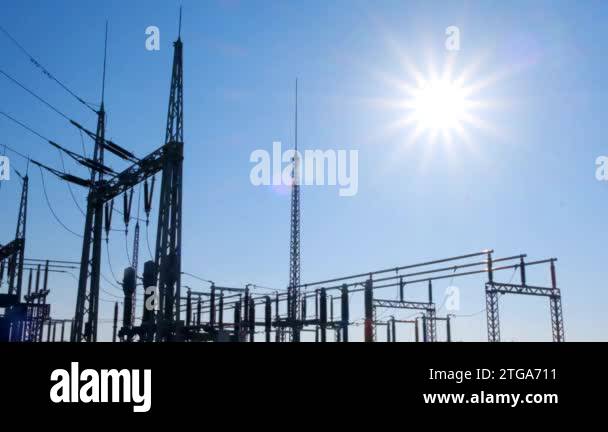 Electricity concept.Power station in the rays of the sun on a blue sky ...