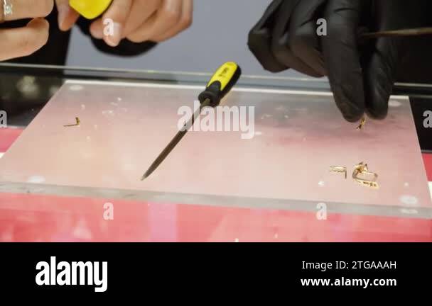 A specialist checks the quality of gold products in a jewelry salon ...