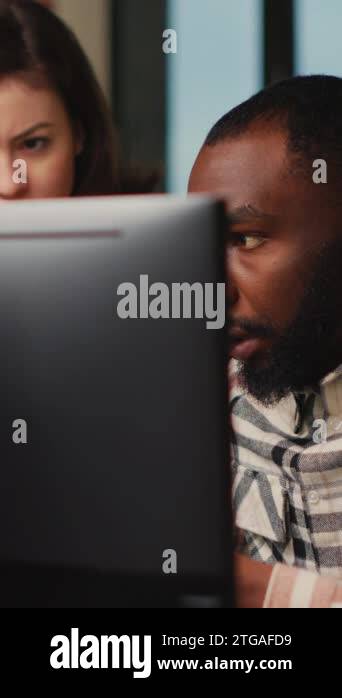 Vertical video: Diverse team of employees working on software development with manufacturing ...