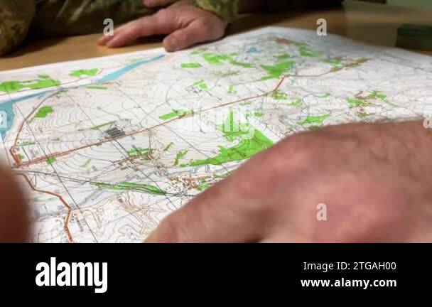 Officer shows important objects on the map with his hand with Watch ...