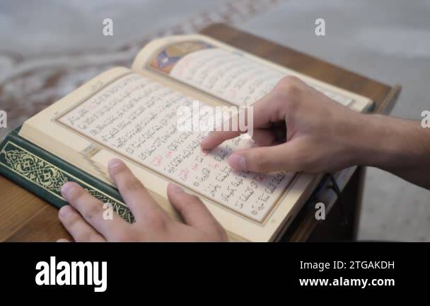 Reading Quran on wooden lectern, islamic holy book in arabic script ...