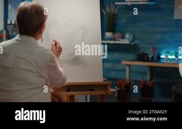 Senior artist using pencils to draw artwork sketch design on canvas ...