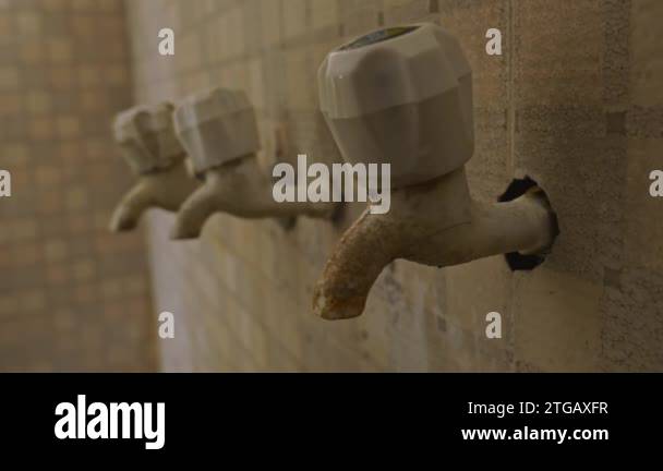 Water is leaking with drips from old plastic tap inside a bathroom ...