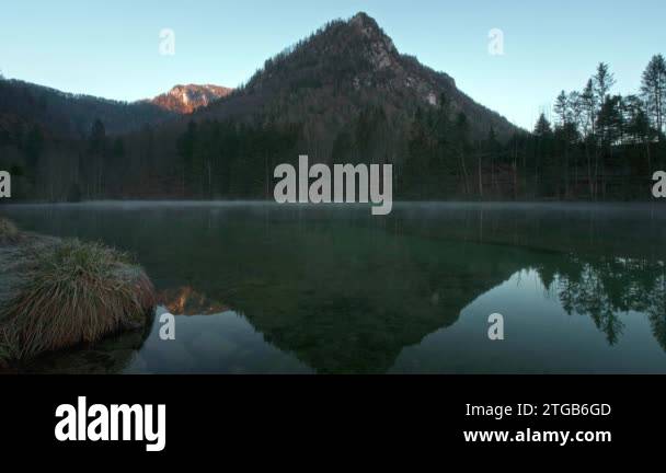 Lake Zwingsee on a spring morning. Mist floats on the turquoise color ...