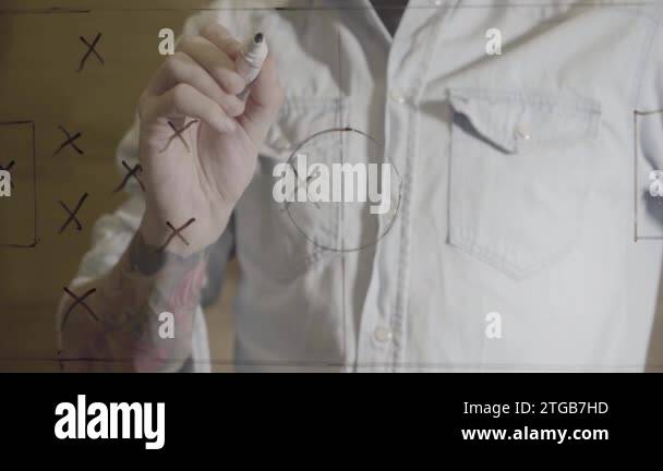 Soccer coach drawing soccer tactics on glass with black marker ...