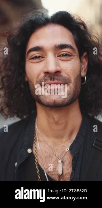 VERTICAL VIDEO: Young attractive italian guy with long curly hair and ...