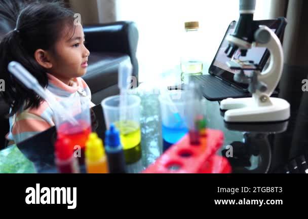 Asian little girl doing science lab experiment with liquids and ...
