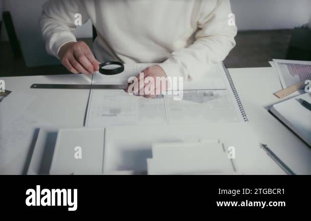 Man is measuring and looking closely at blueprints, using ruler and ...