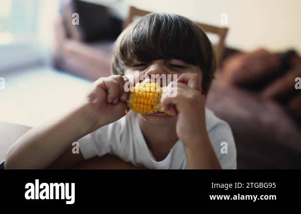 Child eating CORN at home. One little boy snacking nutritious FOOD ...