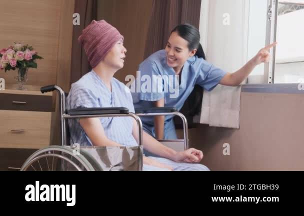 Uniformed young Asian female therapy doctor encouraging wheelchair male ...
