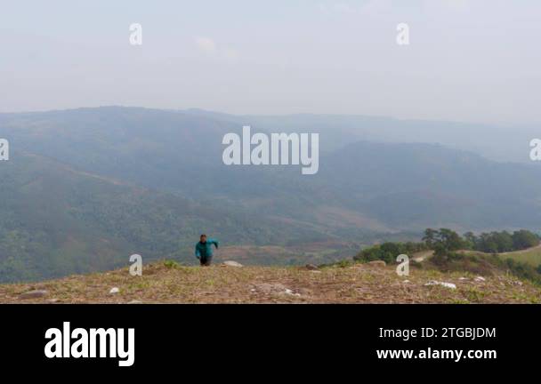 man running on mountain top with misty mountain rage background from ...
