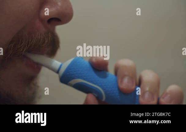 Man brushes his teeth with an electric toothbrush. Daily routine ...