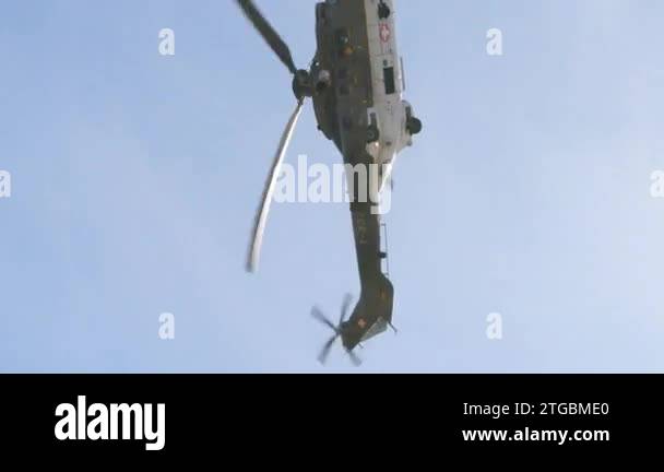 Military helicopter in flight at high speed in a narrow mountain valley ...