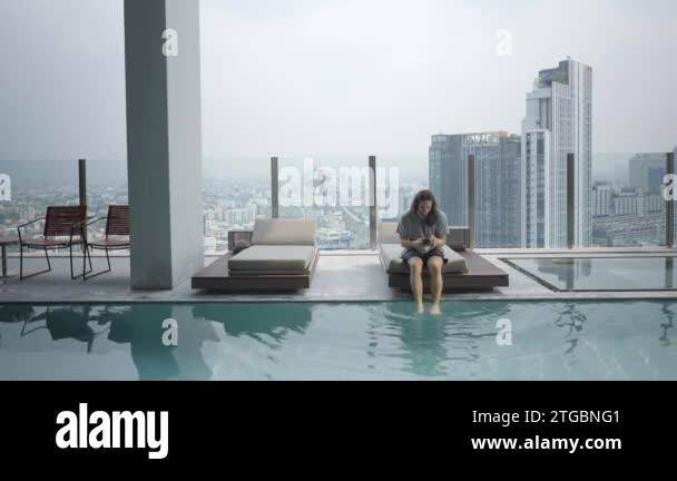 Digital Nomad Using His Smartphone, Sitting On The Swimming Pool Of A ...