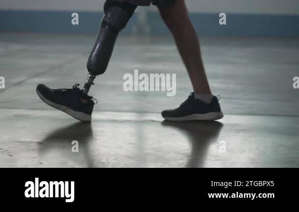 Disabled person walking with his prosthetic leg indoors. Amputee man ...