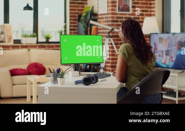 Female freelancer using computer with greenscreen, work from home with ...