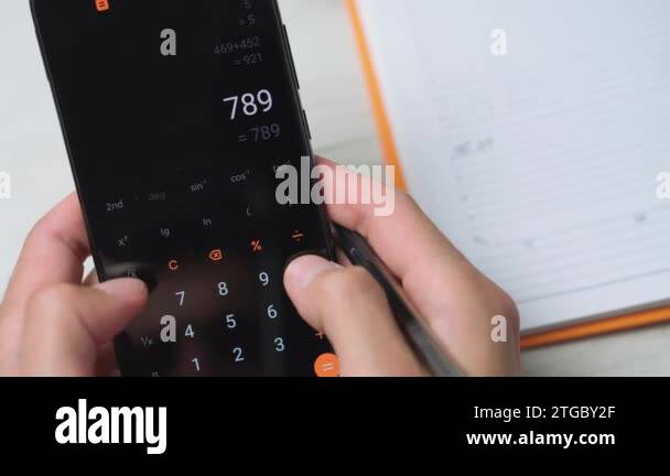A person calculates utility bills and receipts using a smartphone ...
