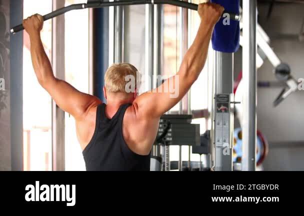 Adult man lifting weights and working out in a health club fitness ...