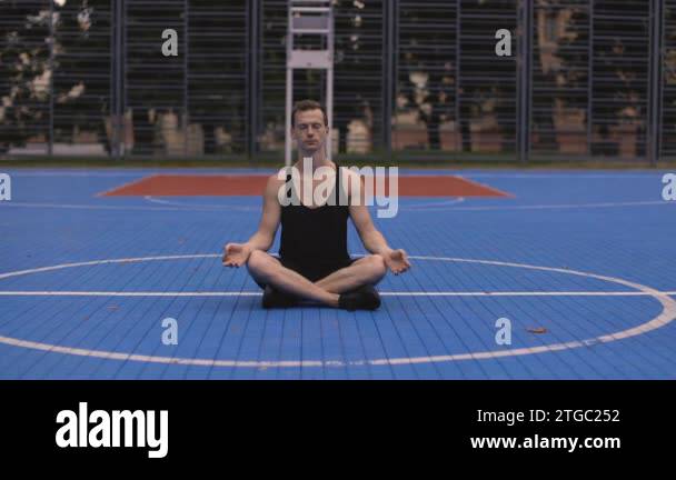 Relaxed man doing exercise and meditation yoga on gym outdoor. Fitness ...