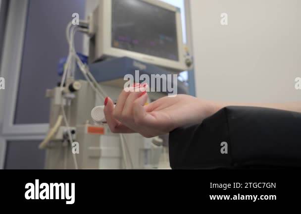 A womans hand is connected to a computer, monitoring patients pulse. A ...
